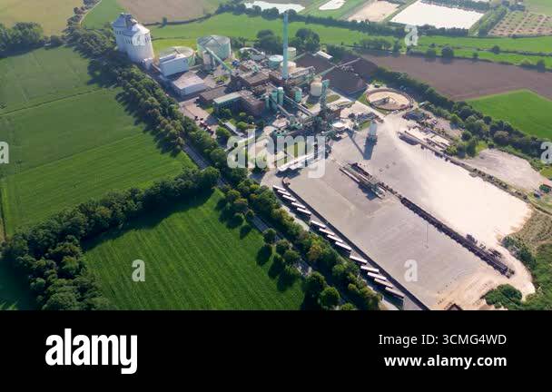Aerial view of an industrial complex surrounded by green fields and ...