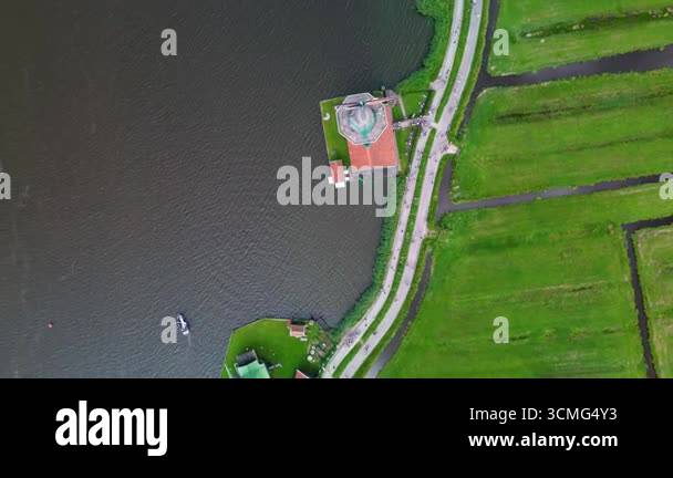 A stunning aerial view of traditional Dutch windmills beside a winding ...