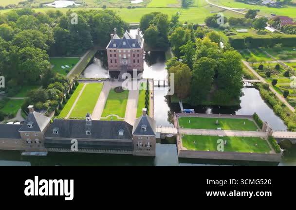 Aerial view of a grand estate surrounded by water and greenery. Brick ...