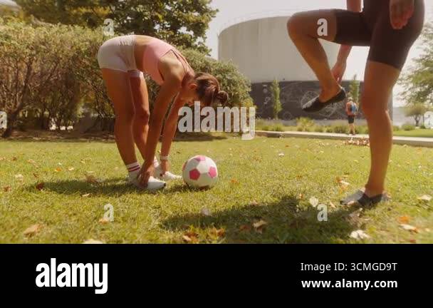 Two friends are happily enjoying playing soccer together in a sunny ...
