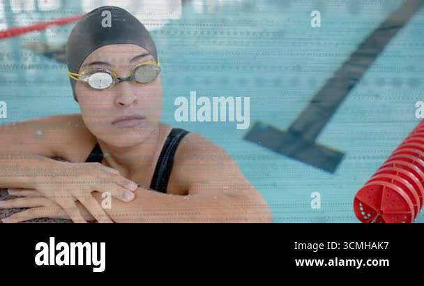 Swimmer emerging from water gripping pool edge in yellow goggles ...