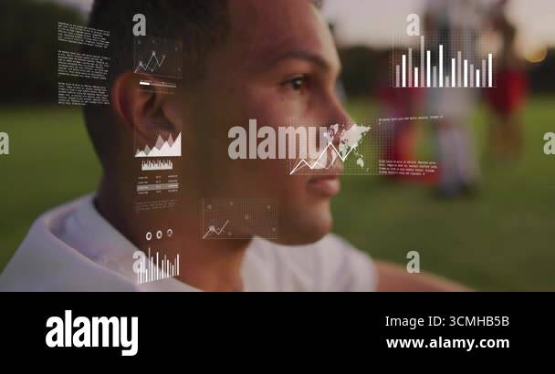 Seated soccer athlete gazing on dusk pitch activating tech HUD graphs ...