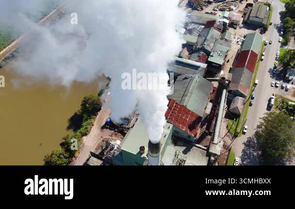 Drone footage captures a factory releasing smoke beside a river ...
