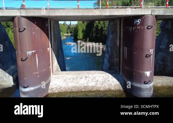 Drone footage of a concrete drainage channel under the footbridge of an ...