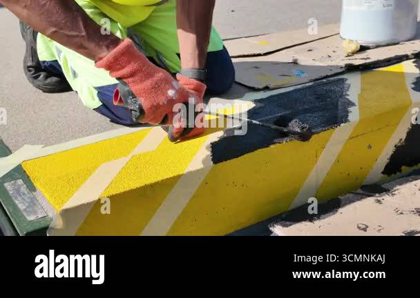 Coating safety stripes on railway platforms. Coating railway platforms ...