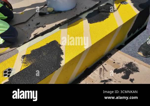Painting safety stripes on railway platforms. Marking railway platforms ...