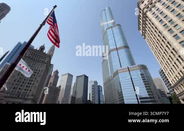 Low angle view of Chicago skyscrapers with United States flag waving in ...