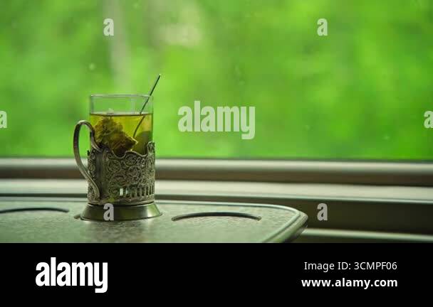 Green tea in a glass on a table in a moving train. High quality 4k ...