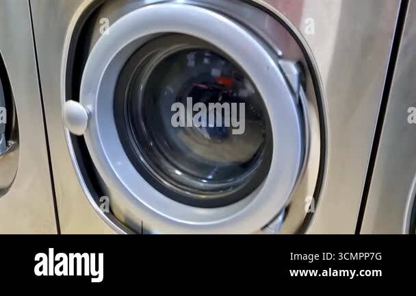 A close-up view of a front-loading washing machine in action. the ...
