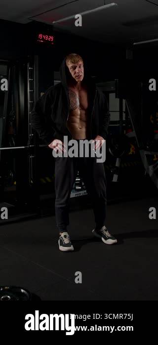 male athlete stands in a gym with a focused expression showcasing his ...