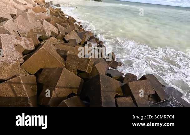 Waves hitting concrete blocks on the shore Stock Video Footage - Alamy