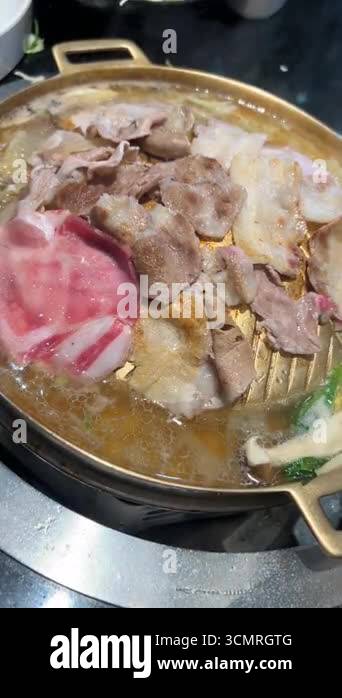 4K close up video of Thai BBQ Mookata style, grilling pork and beef on ...