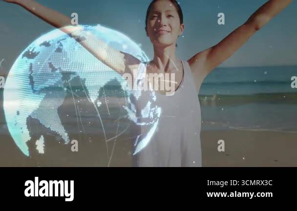 Woman raising arms on beach and causing rotating globe hologram ...