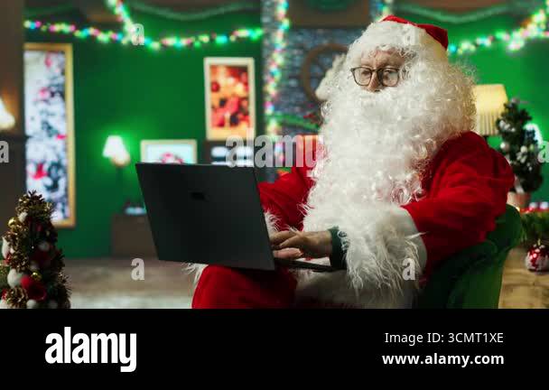 Santa Claus reads letters from kids on laptop and replying in Christmas ...