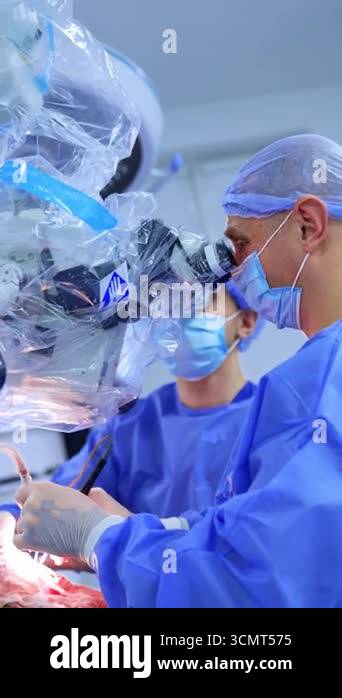 Professional male Caucasian doctor looks at microscope and applies ...