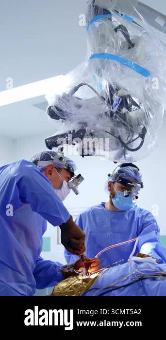 Male surgeon putting much efforts applying surgical instrument. Doctors ...