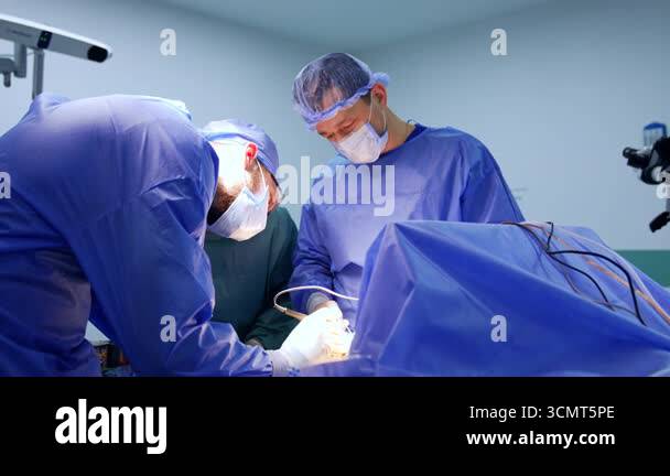 Caucasian male doctors are cooperating at neurosurgery. Bearded surgeon ...