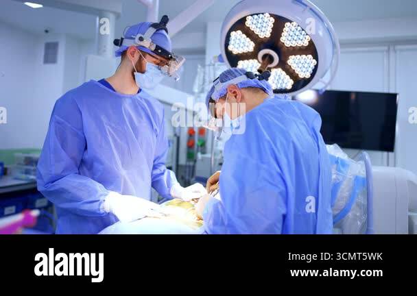 Surgeons in critical surgery. Two skilled medical professionals operate ...