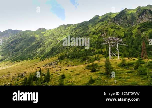 Power line supports installed in the green mountains. Lovely pine trees ...