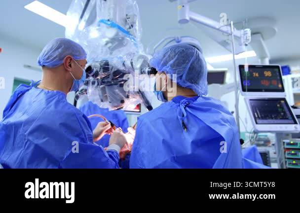 Rear view of the cooperating surgeons working at operation ...