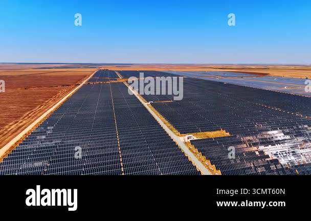 Large solar farm in sunny area. Rows of solar panels stretch across a ...