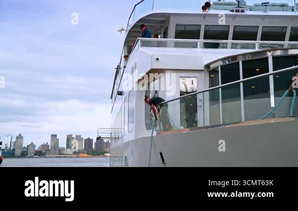 Two men work on board of the cruise boat. Worker throws the life vest ...