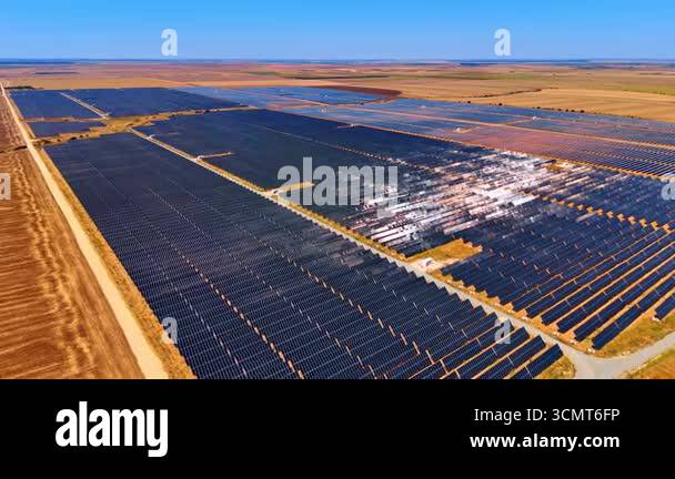 Vast solar farm in open landscape. Solar panels stretch across a wide ...
