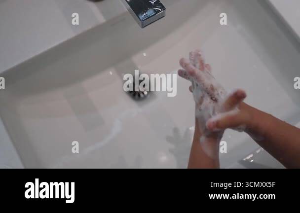 Overhead angle shows thick lather covering small palms as handwashing ...