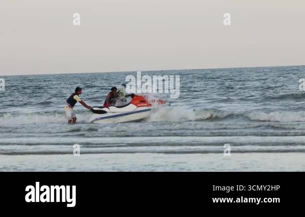 Two people riding a jet ski across the sea Stock Video Footage - Alamy