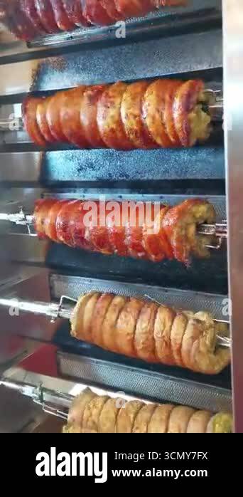 Witness the mesmerizing process of grilling pork belly rolls on skewers ...