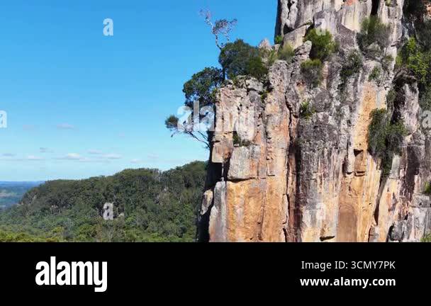 Aerial footage showcasing the majestic Nimbin Rocks under clear blue ...