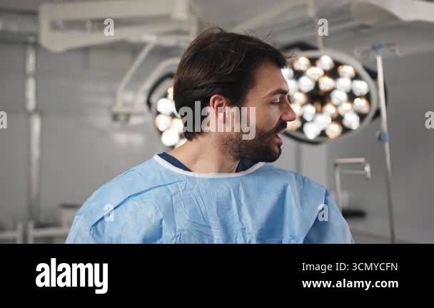 A male doctor, possibly of Mediterranean descent, prepares for surgery ...