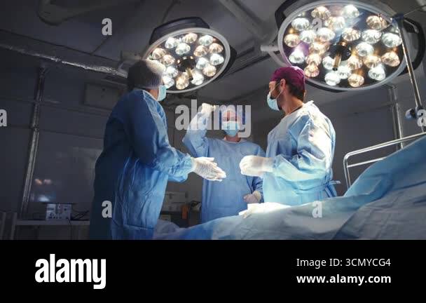 Medical team high-fiving after successful surgery in the operating room ...