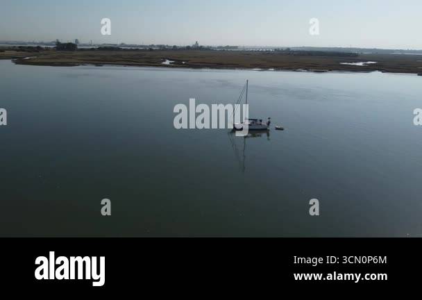 Sailboat anchored in the Marismas del Odiel, that is a sandy ecosystems ...