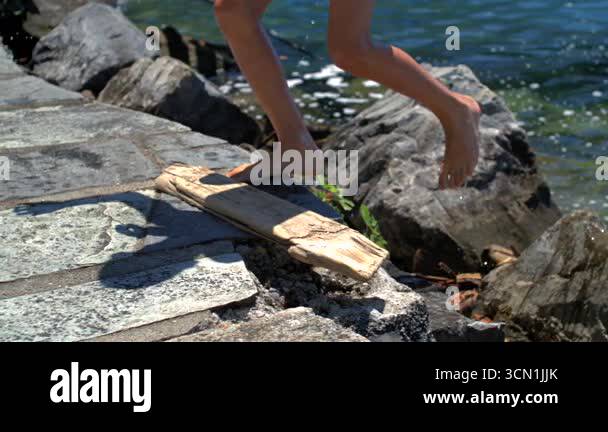 Barefoot child stepping on rocky path by lake, slow motion video ...