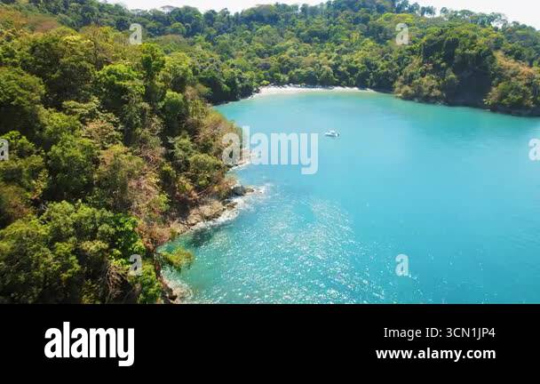 Peaceful bay with small boat floating near secluded beach in Playa ...