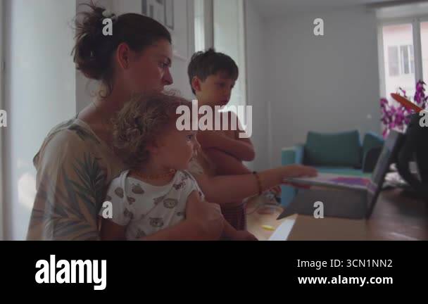 Mother turning off tablet while holding toddler and standing beside ...