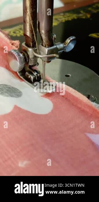 African mending violet fabric with sewing machine in action. Lifting ...