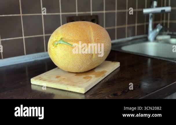Macro zoom demonstration of a ripe yellow melon with a green stem ...