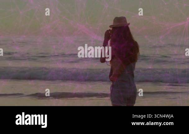 Woman raising camera then lowering and lifting again while capturing ...