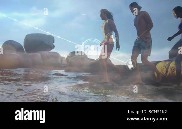 friends dipping feet into tidal pools spawning digital network map of user icons across ...