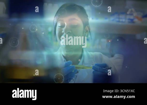 Lab scientist raising test tube to eye level, examining liquid while ...