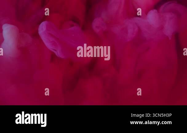 Cloud dye. Pigment stream. Red pink paint explosion on defocused ...