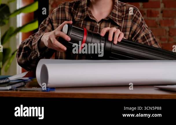 The architect takes rolls of building plans and interior designs out of ...