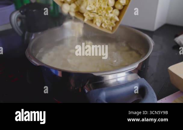 Dropping fresh pasta into boiling water, cooking homemade tortellini in ...