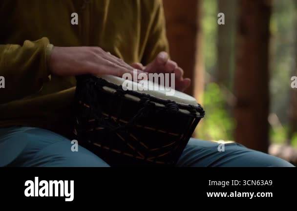 Enjoying rhythmic drumming in the forest while connected to nature and ...