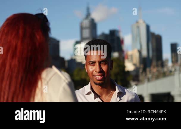 Two people enjoy a casual conversation in front of the iconic skyline ...