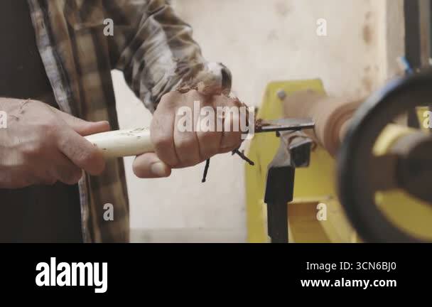 A skilled artisan shapes a flute on a wood lathe, showcasing meticulous ...