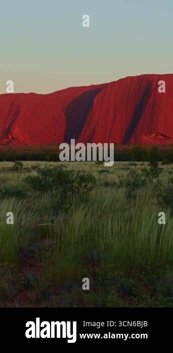 Breathtaking view of Uluru at sunset, capturing the vivid red hues of ...