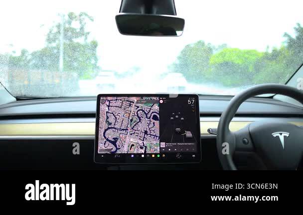 Tesla interior with autopilot navigation during a rainy drive on Gold ...